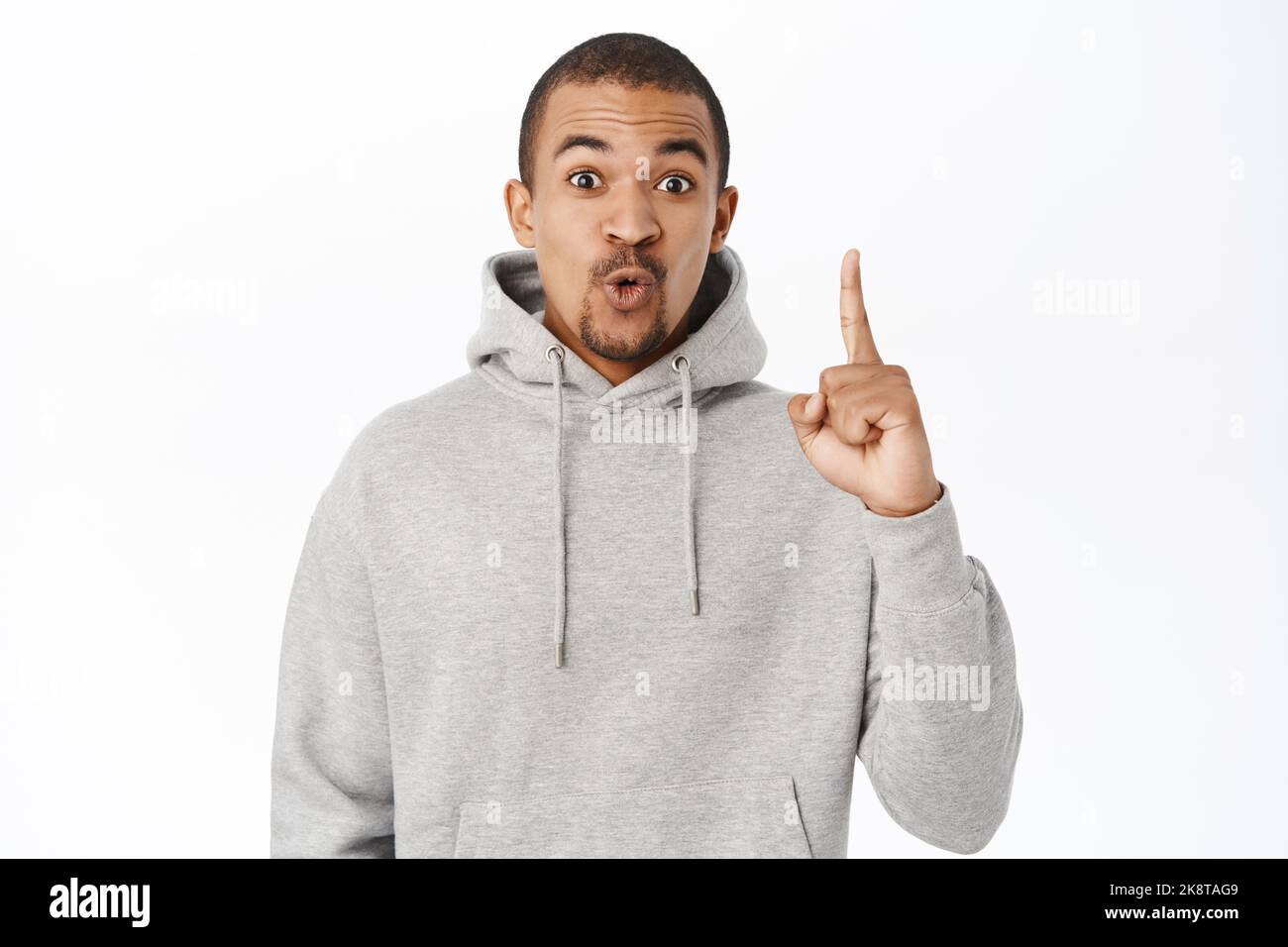 Enthusiastic guy say wow, looks impressed, points up, shows logo or ...