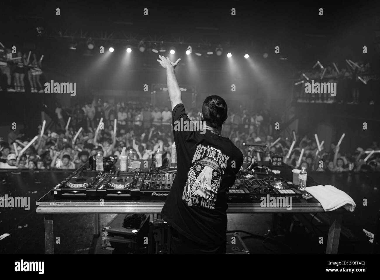 A DJ on stage playing music to college kids, during music festival in ...