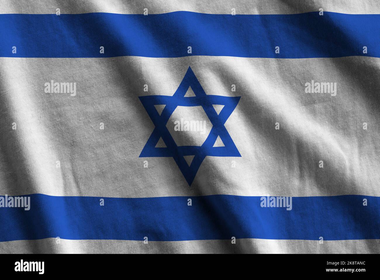 Israel flag with big folds waving close up under the studio light ...