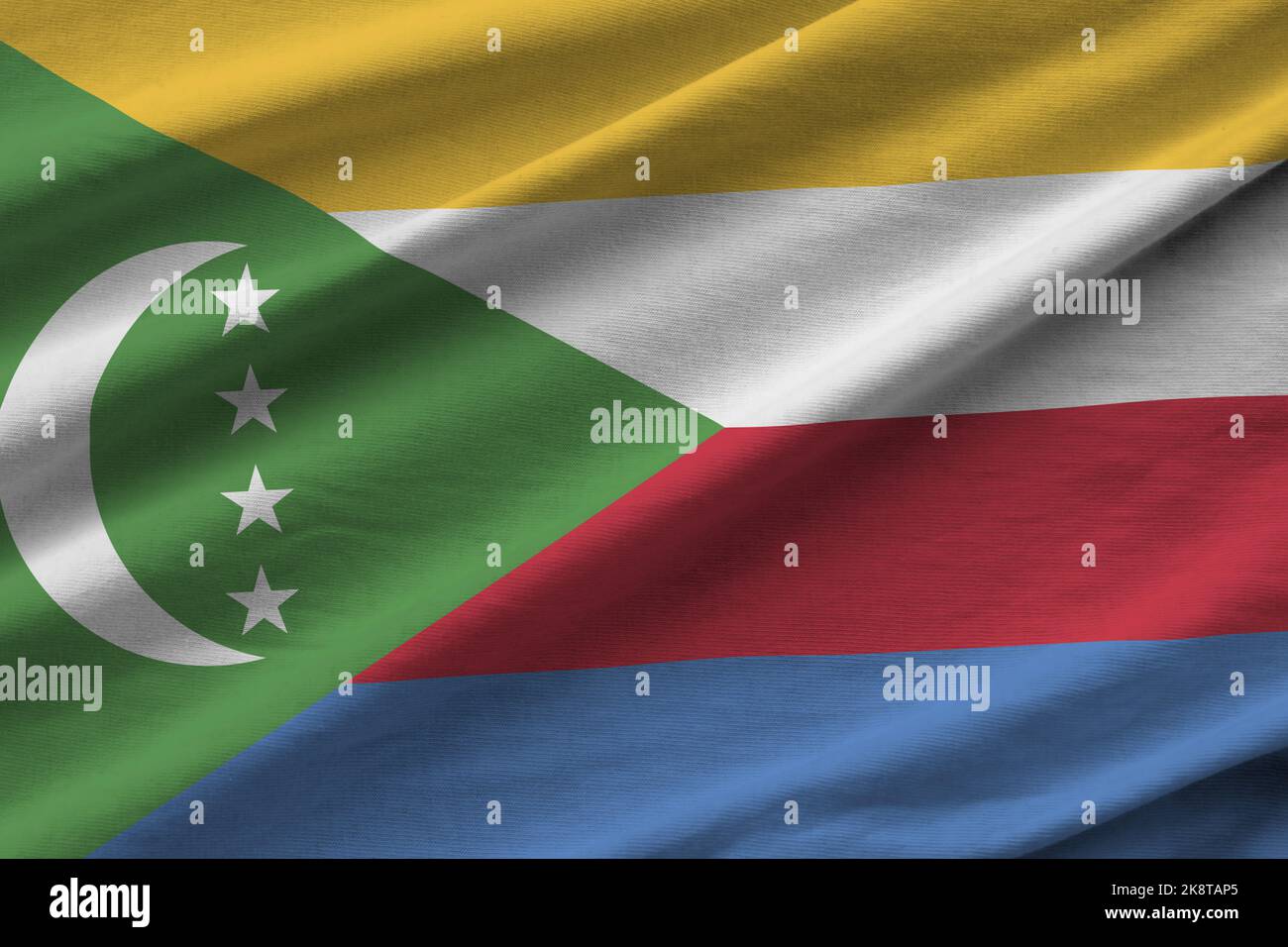 Comoros flag with big folds waving close up under the studio light ...