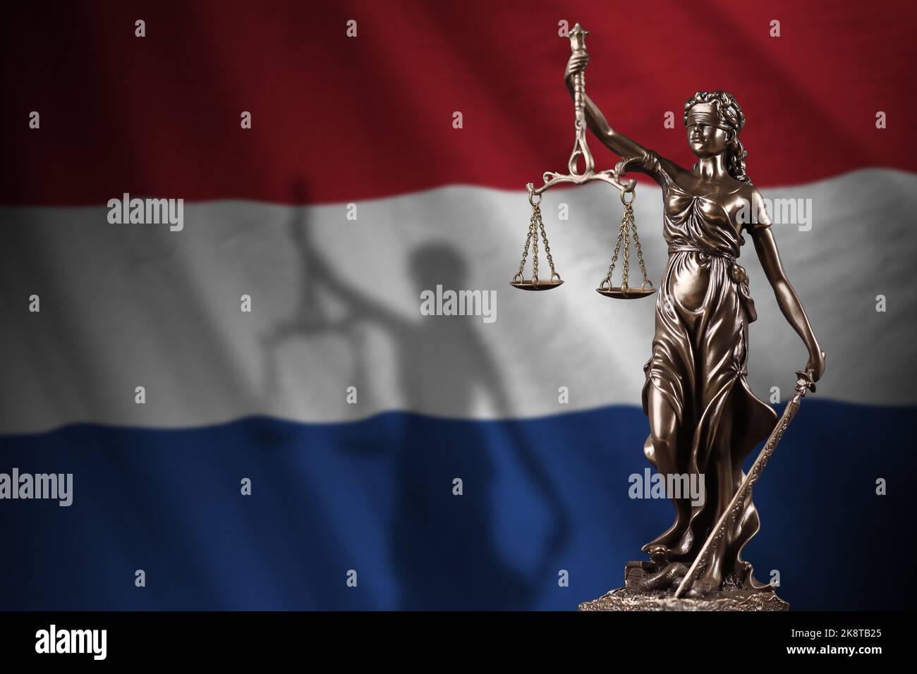 Netherlands flag with statue of lady justice and judicial scales in ...