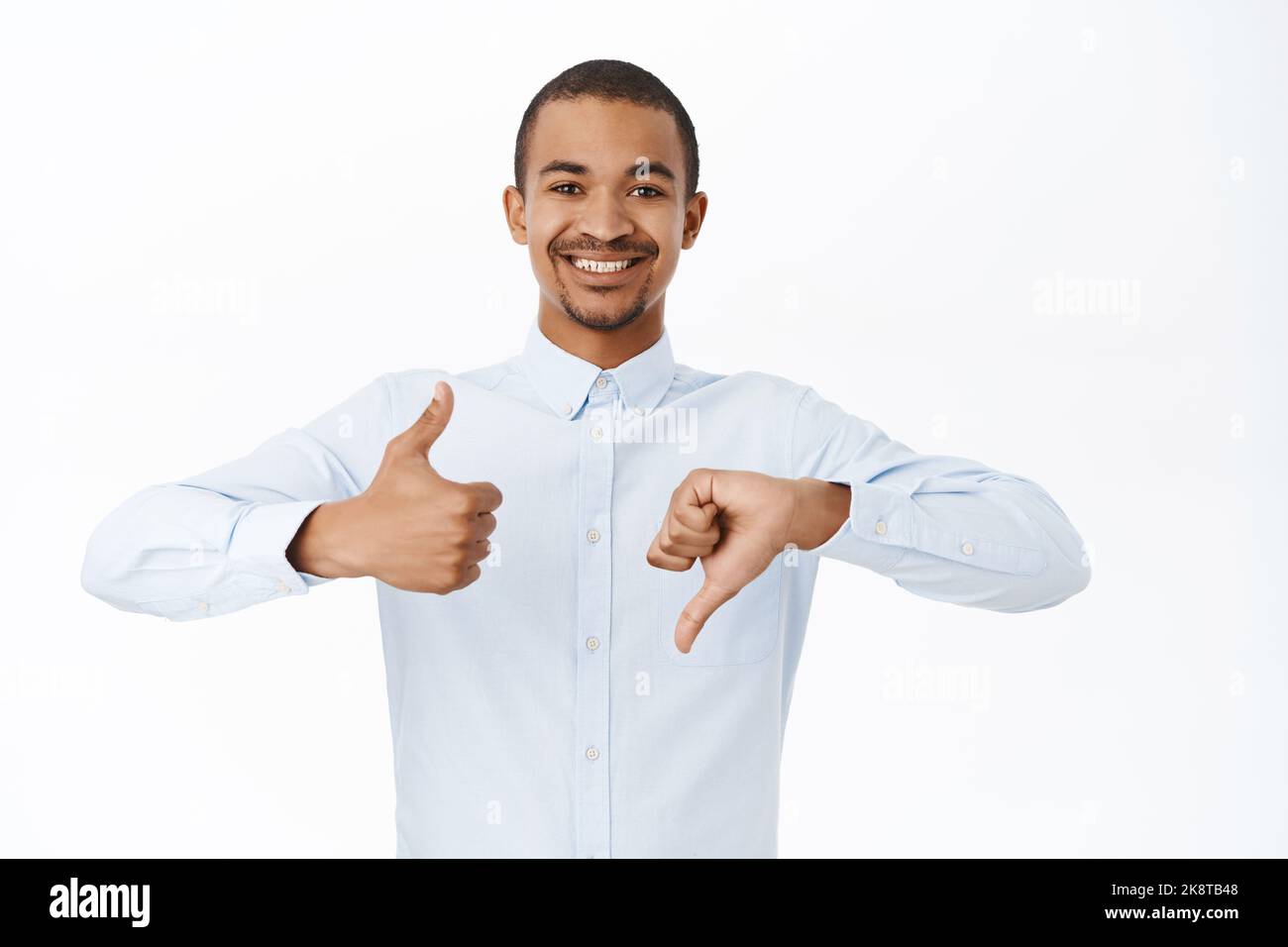 Like or dislike. Handsome man shows thumbs up and thumbs down, negative ...