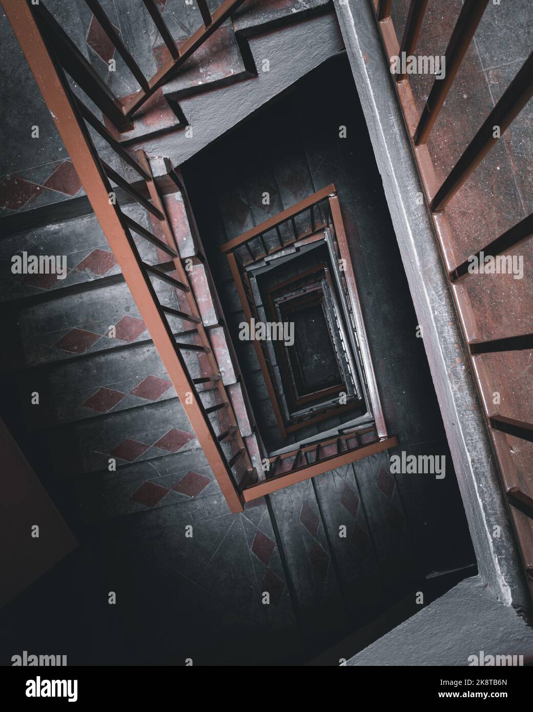 A top view of old winding stairs with wooden handrails - suitable for a ...