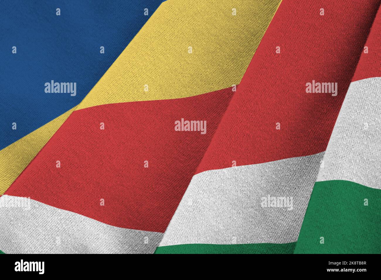 Seychelles flag with big folds waving close up under the studio light ...