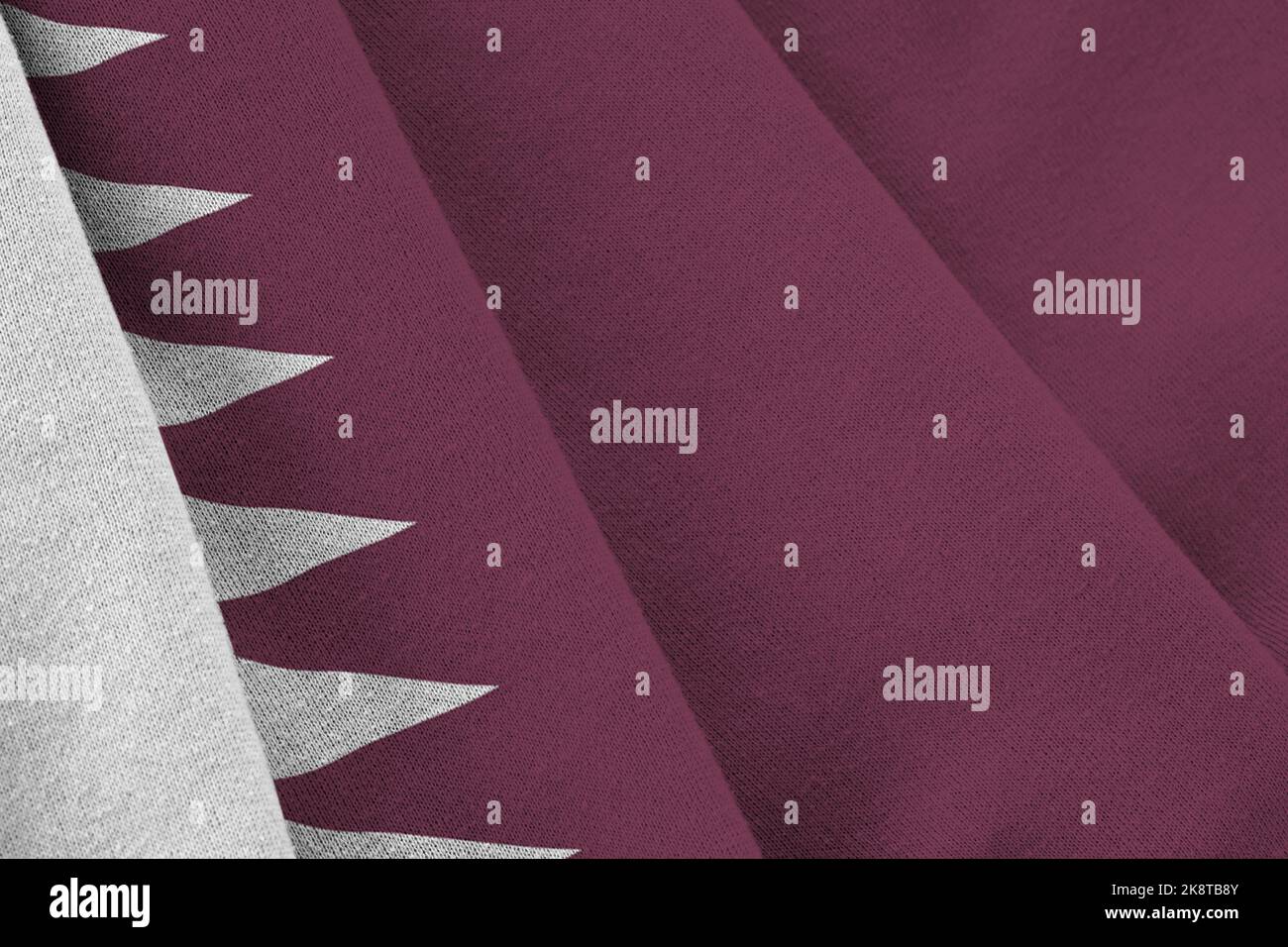 Qatar flag with big folds waving close up under the studio light ...