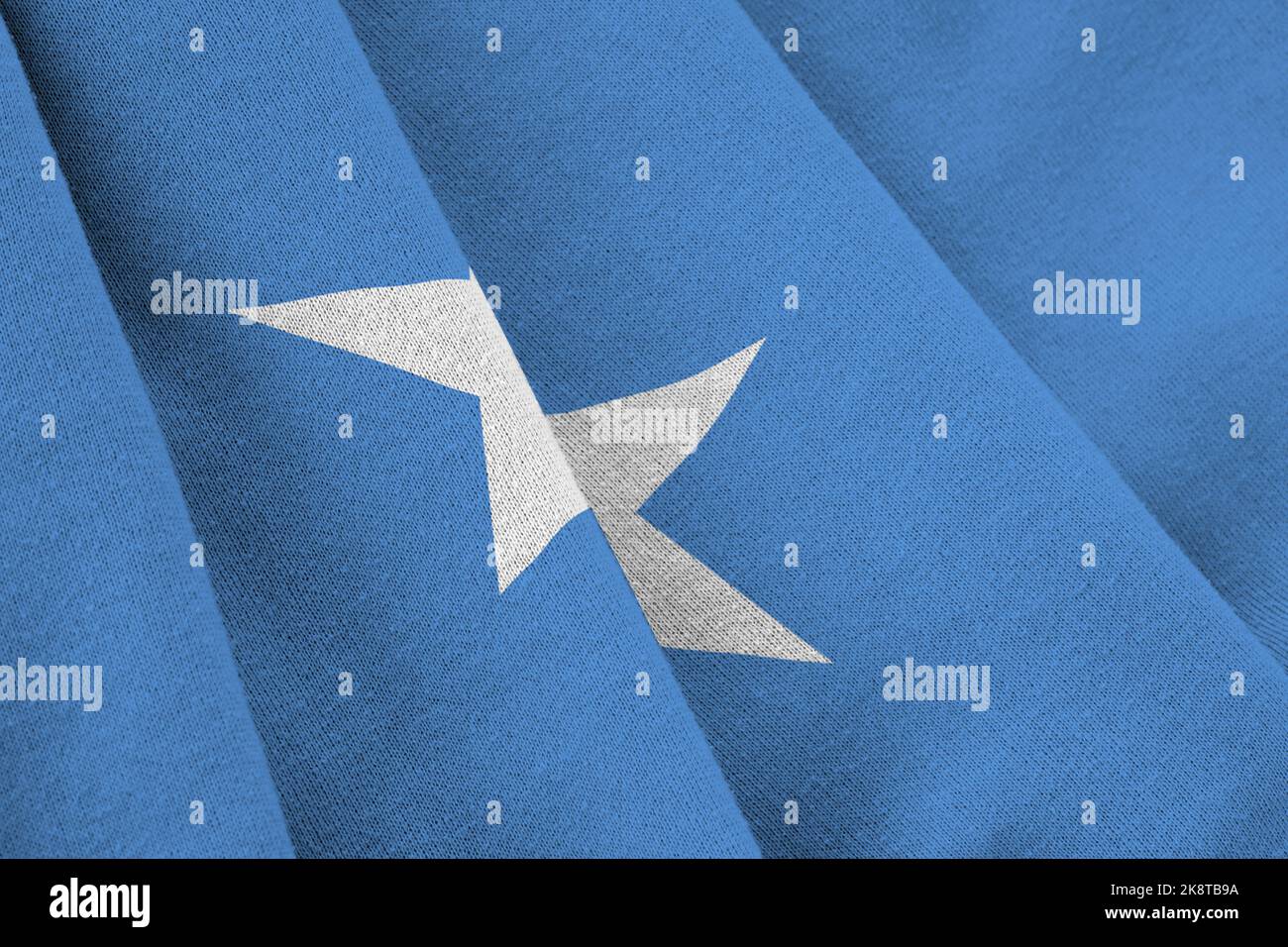 Somalia flag with big folds waving close up under the studio light ...