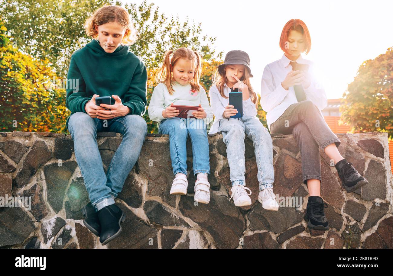 Teenager boy and a sister girls kids sitting and browsing their ...