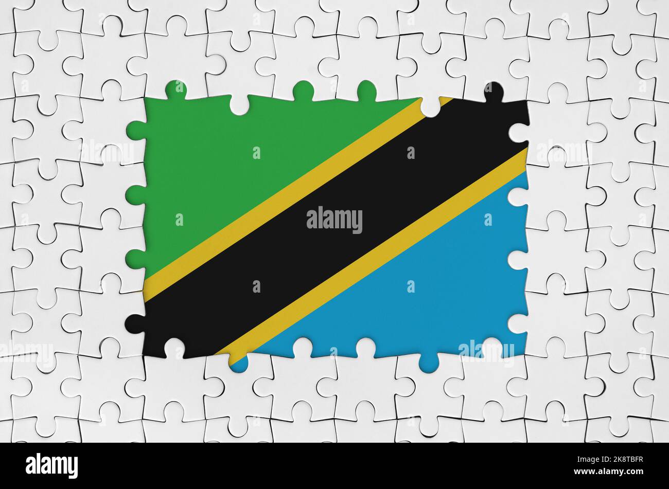 Tanzania flag in frame of white puzzle pieces with missing central ...