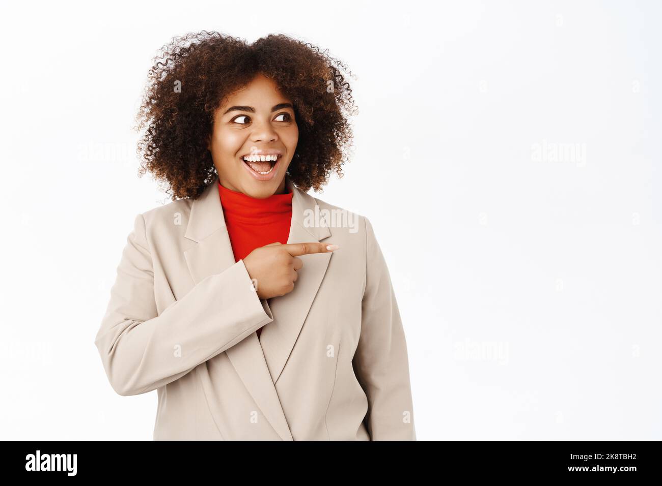 Young smiling saleswoman, business lady pointing finger right, shows ...