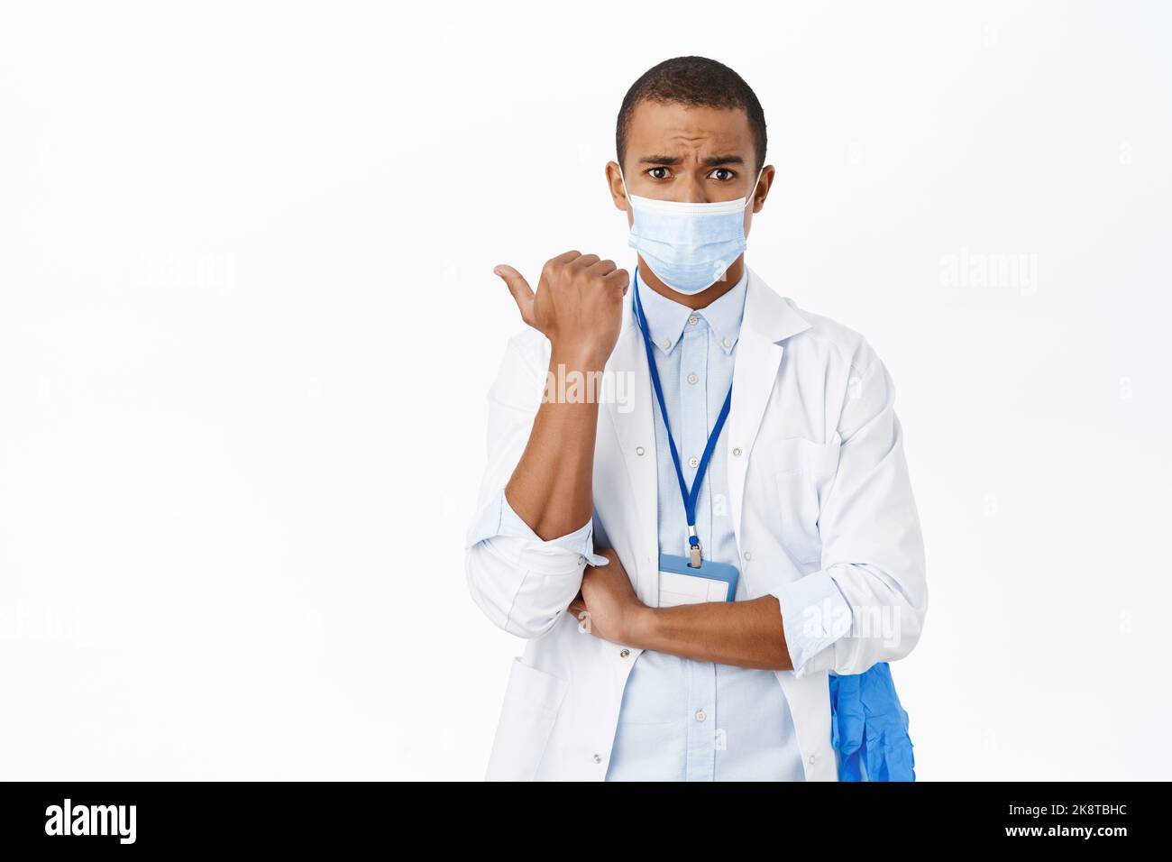 Shocked male physician, hospital doctor in medical mask looks concerned ...