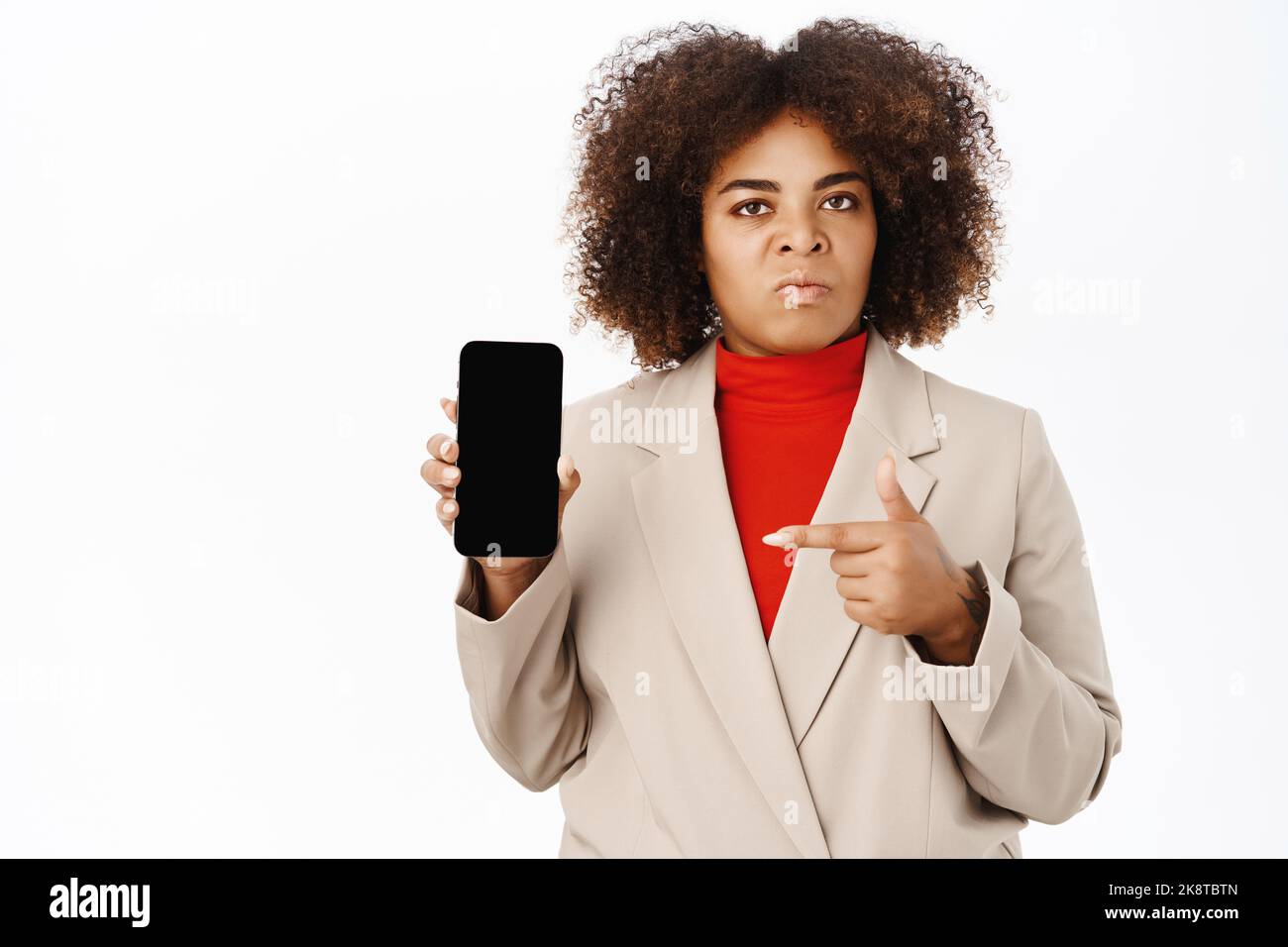 Technology. Angry, serious african american woman, points at smartphone ...