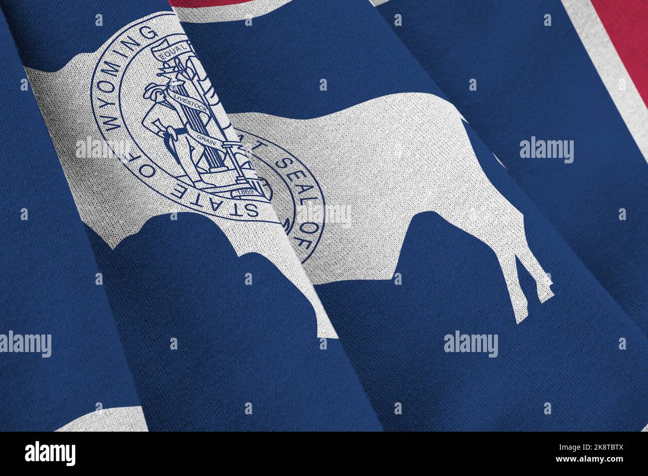 Wyoming US state flag with big folds waving close up under the studio ...