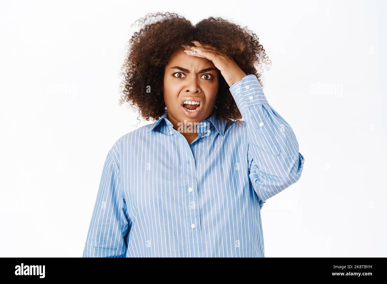 Portrait of black woman looking shocked and concerned at camera, gasps ...