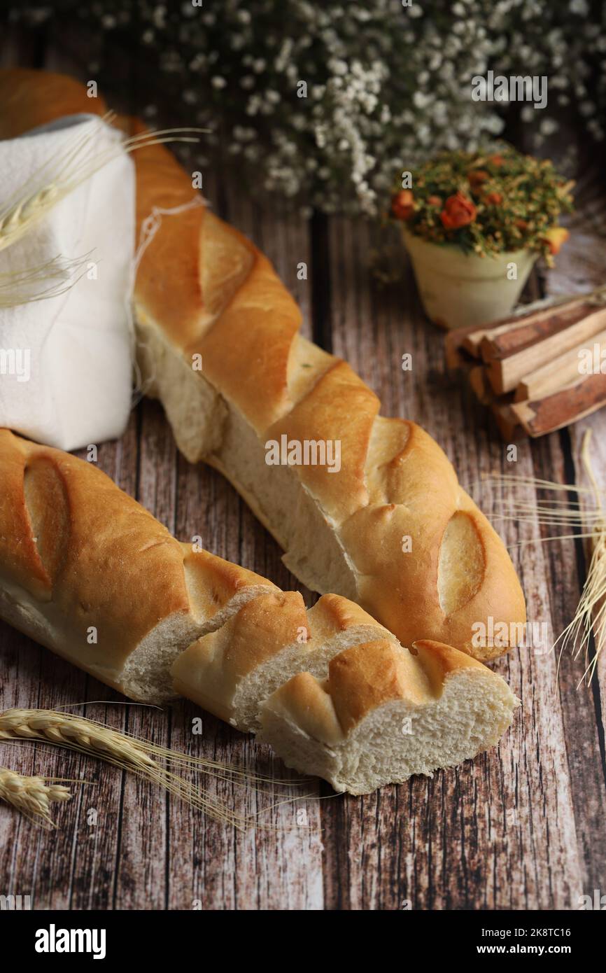 Two french baguettes sliced to eat freshly baked and fresh on a wooden ...