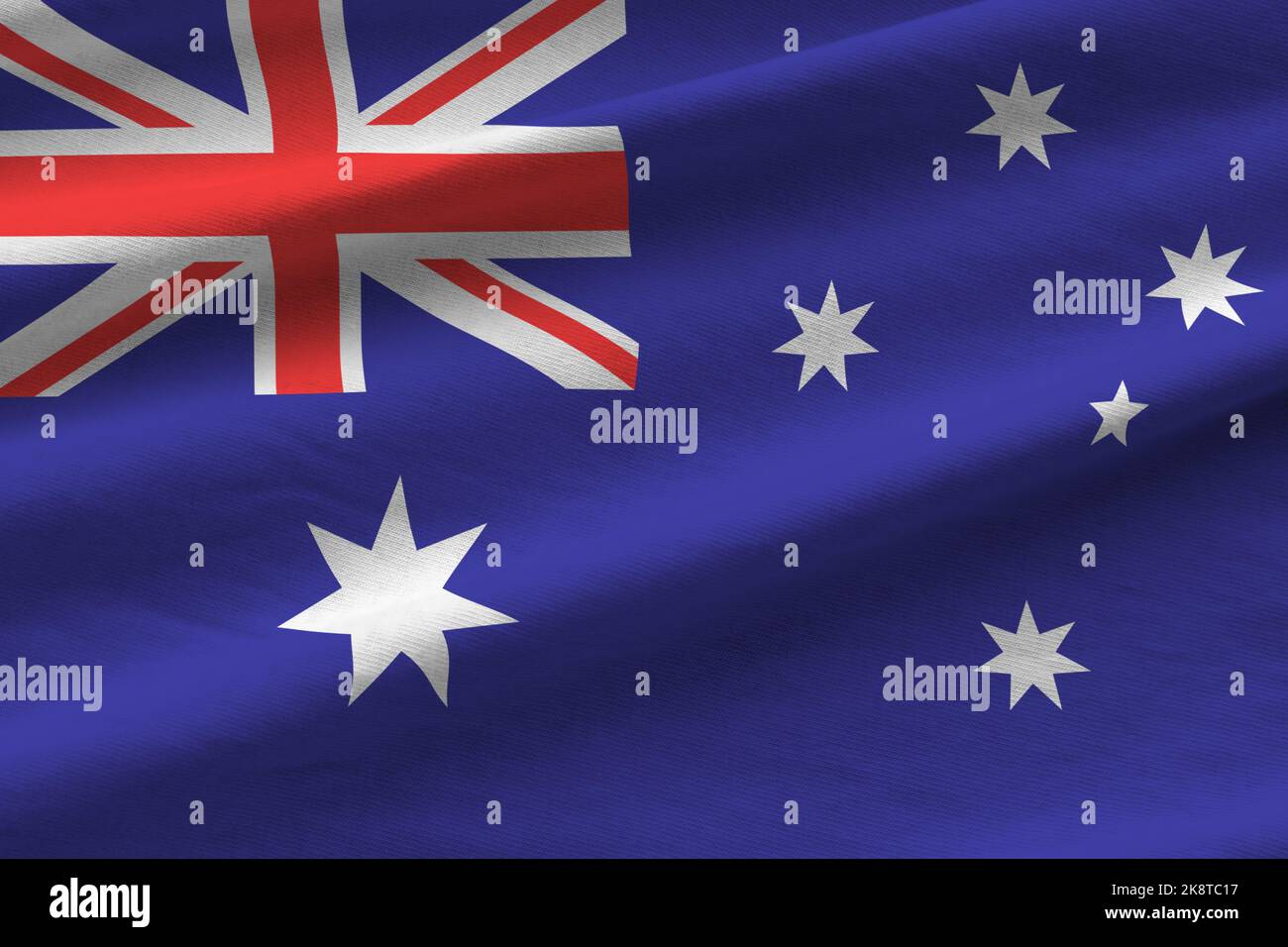 Australia flag with big folds waving close up under the studio light ...
