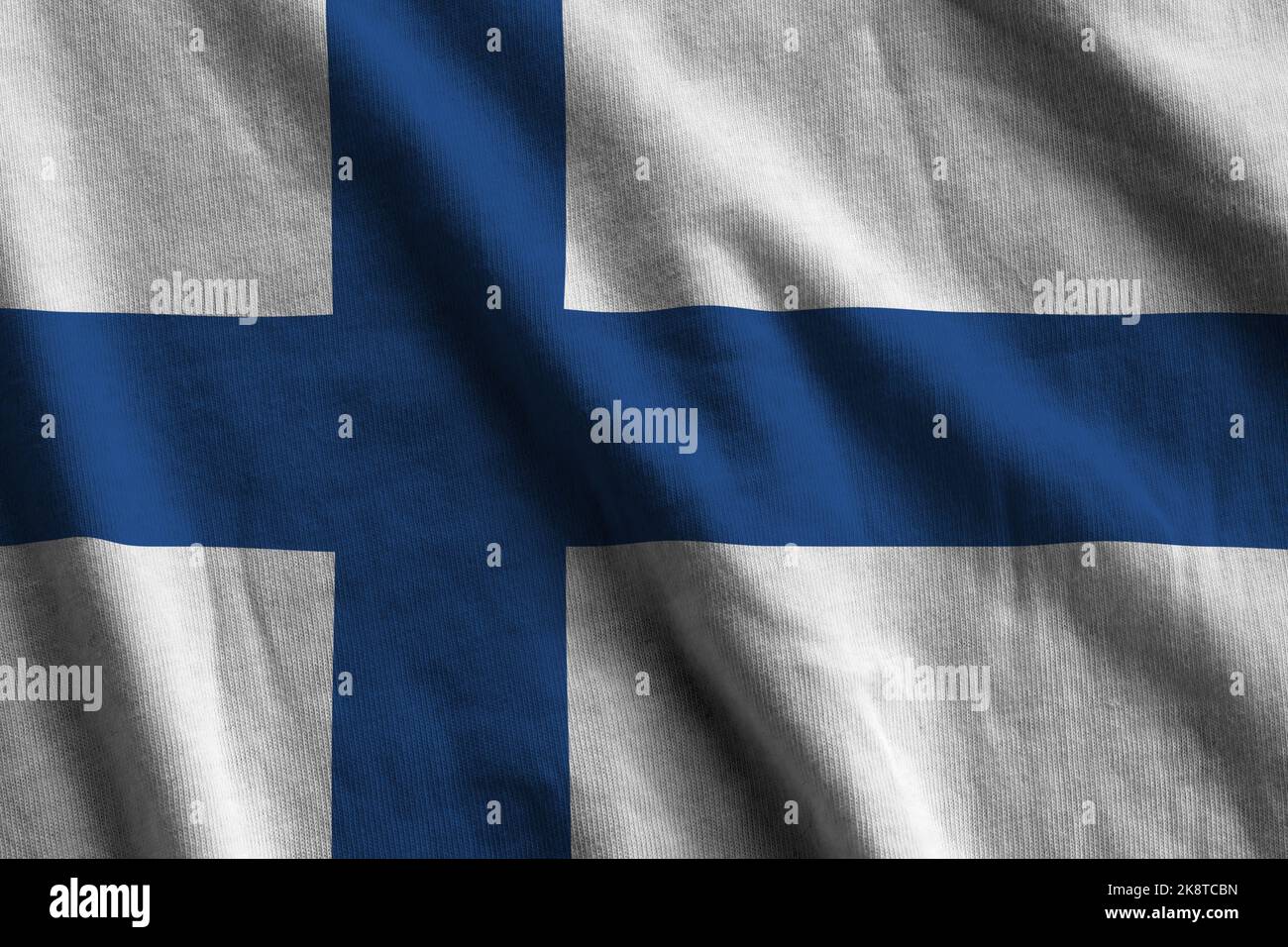 Finland flag with big folds waving close up under the studio light ...