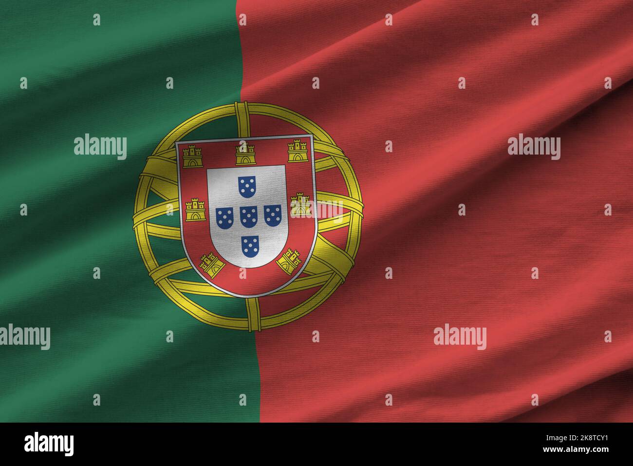 Portugal flag with big folds waving close up under the studio light ...