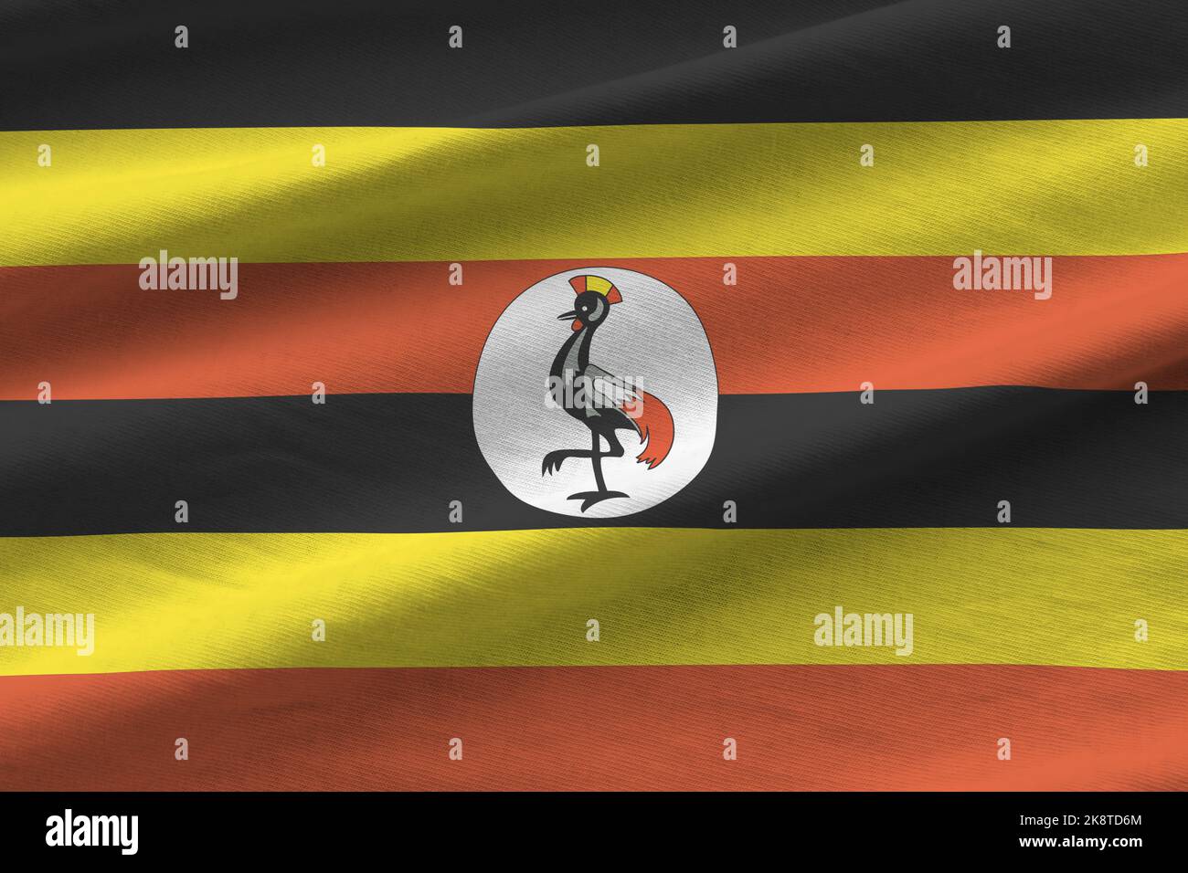 Uganda flag with big folds waving close up under the studio light ...