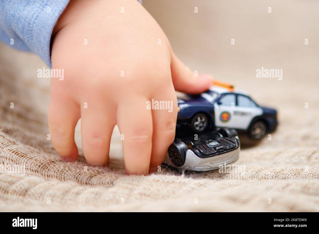 Toddler baby boy is playing with toy cars on the floor in the home room ...