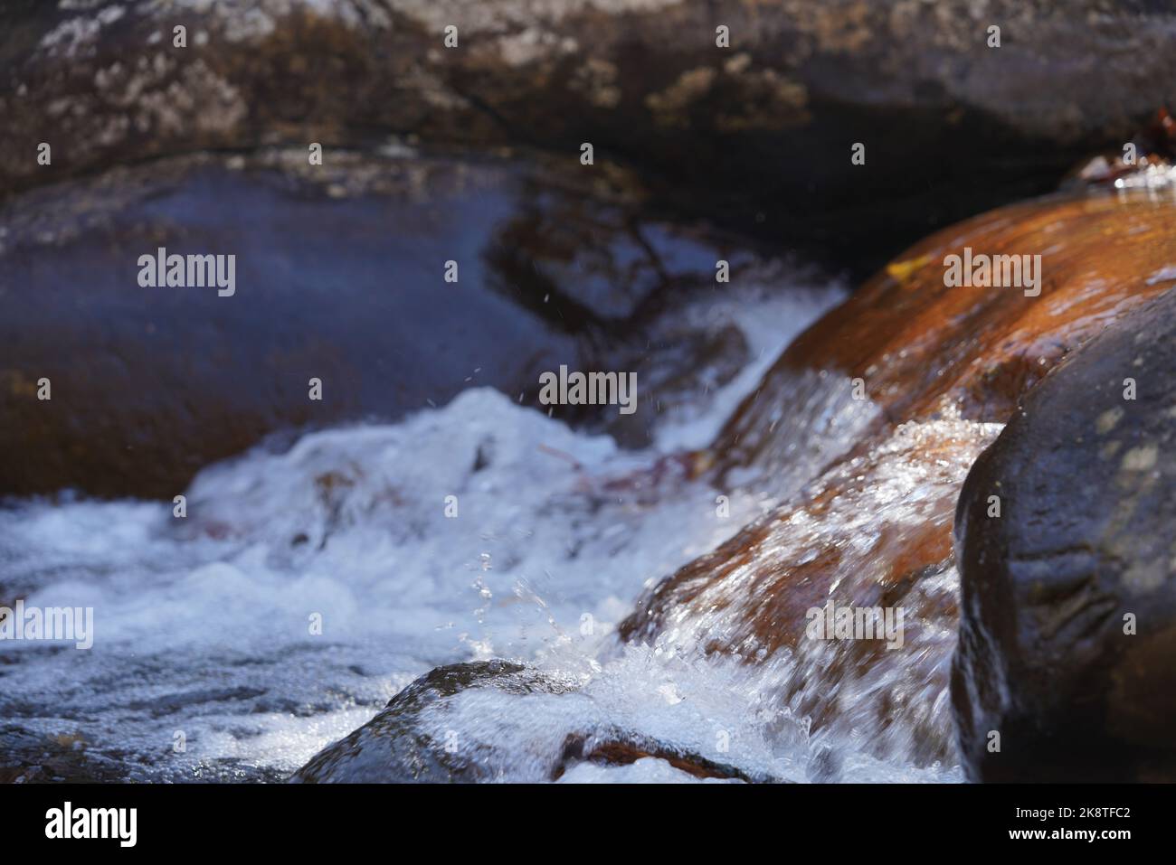 A river current on wet rocks Stock Photo - Alamy