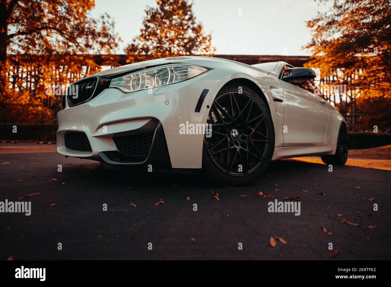 Front view of a modern white BMW M4 on the street during an autumn ...