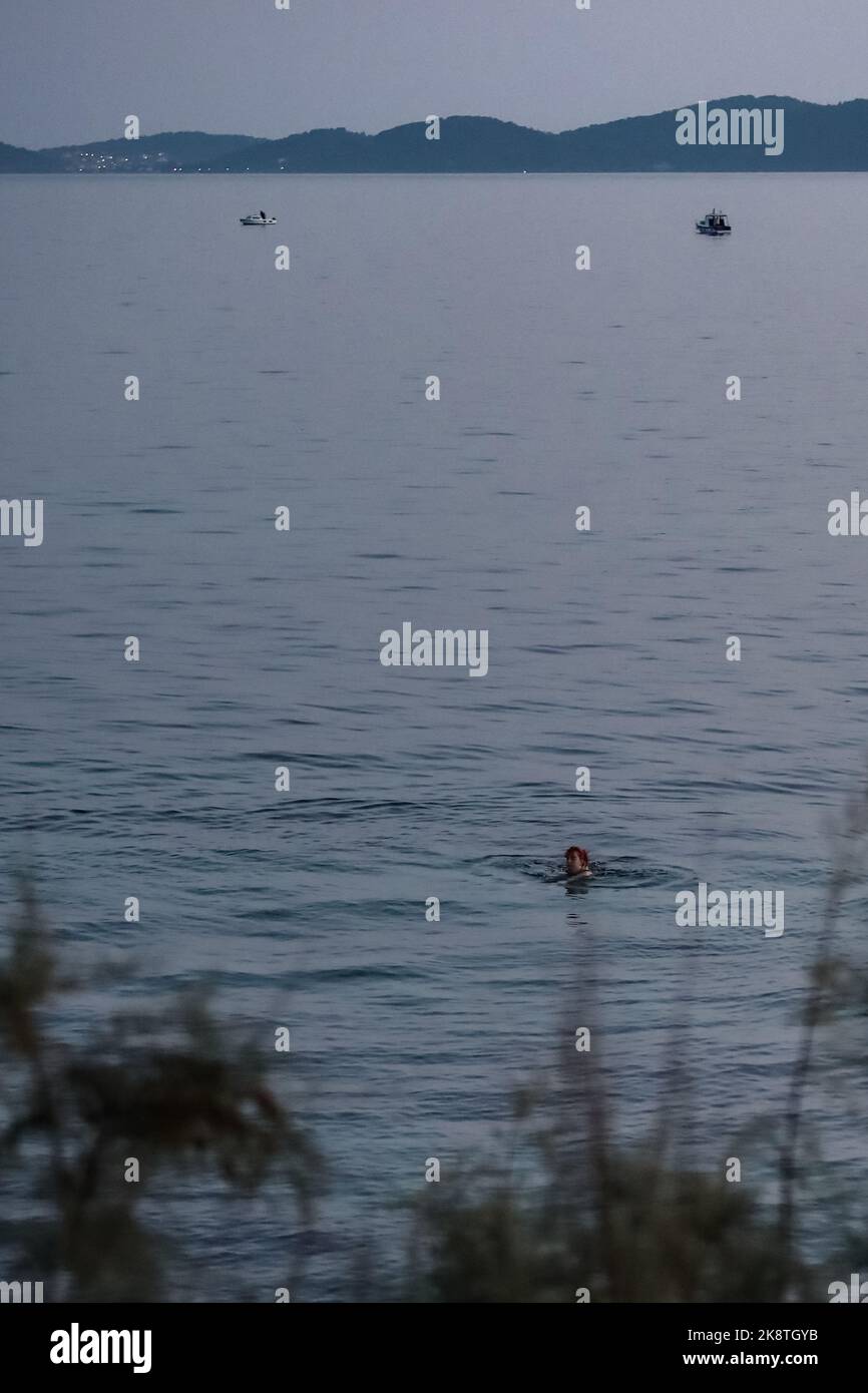 Brave swimmers are seen enjoying an autumn evening swim in the sea, in ...