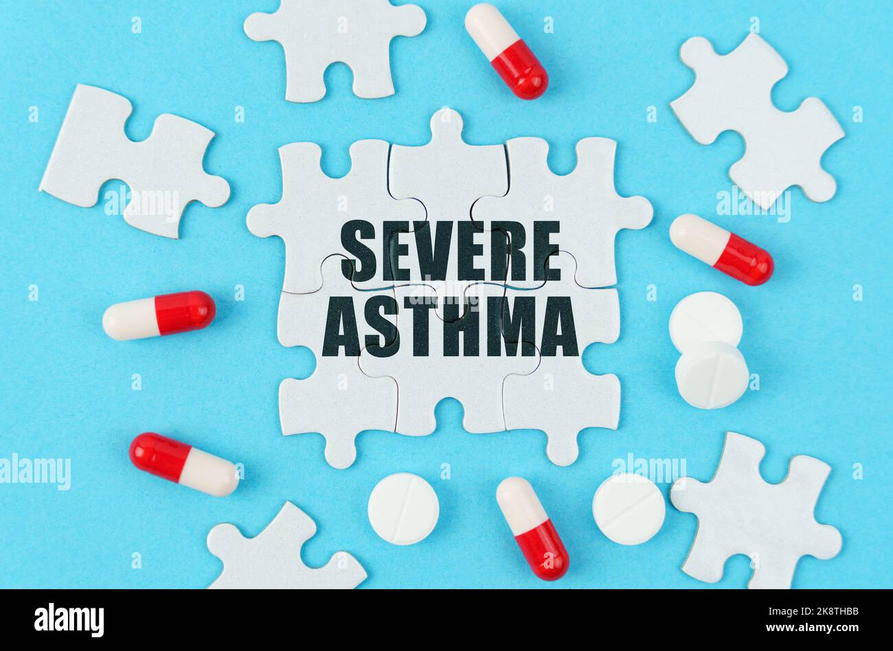 Medical concept. On a blue background, pills, capsules and puzzles with ...