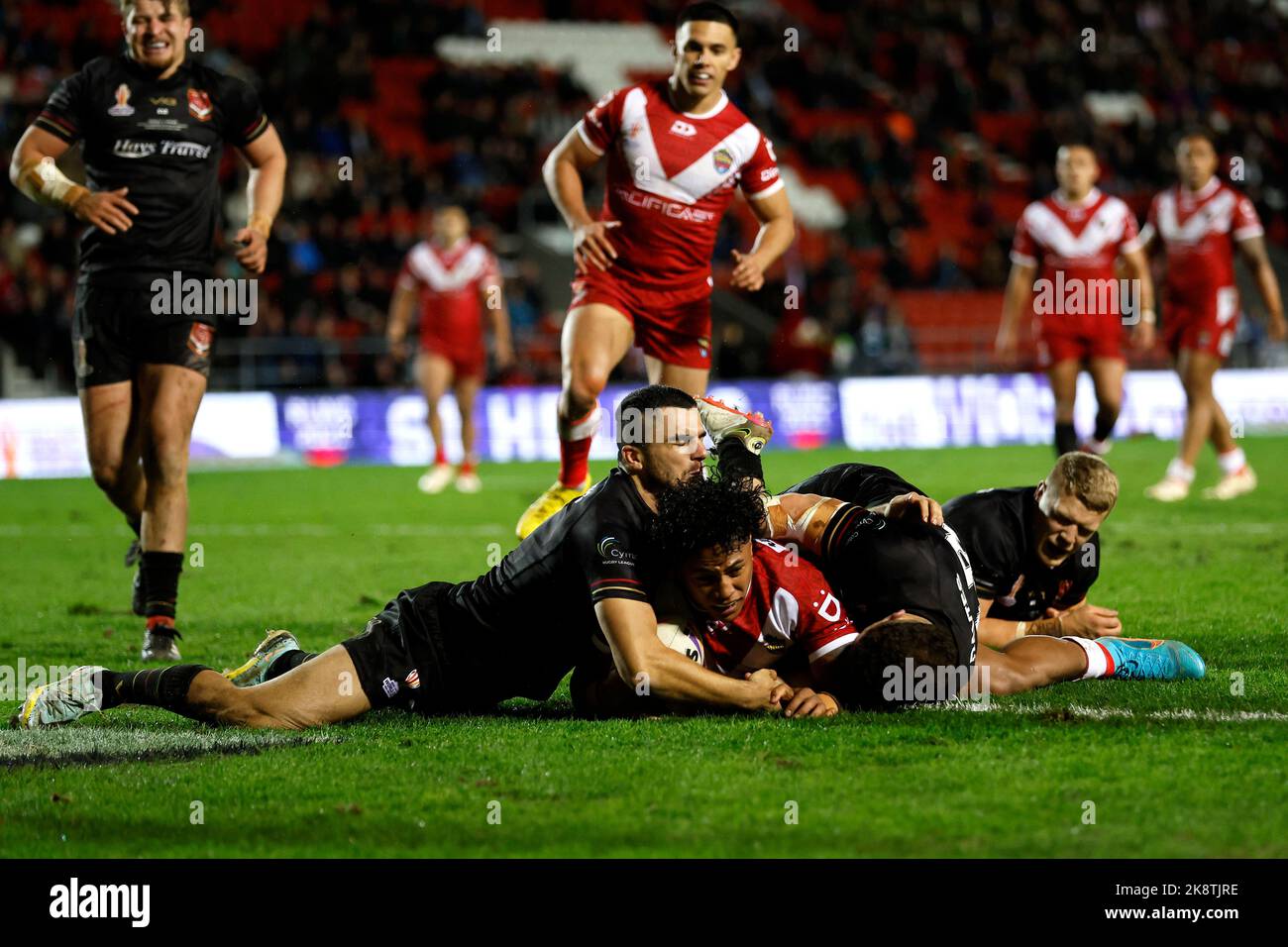 Tonga's Tesi Niu (centre) scores his side's fourth try of the game ...