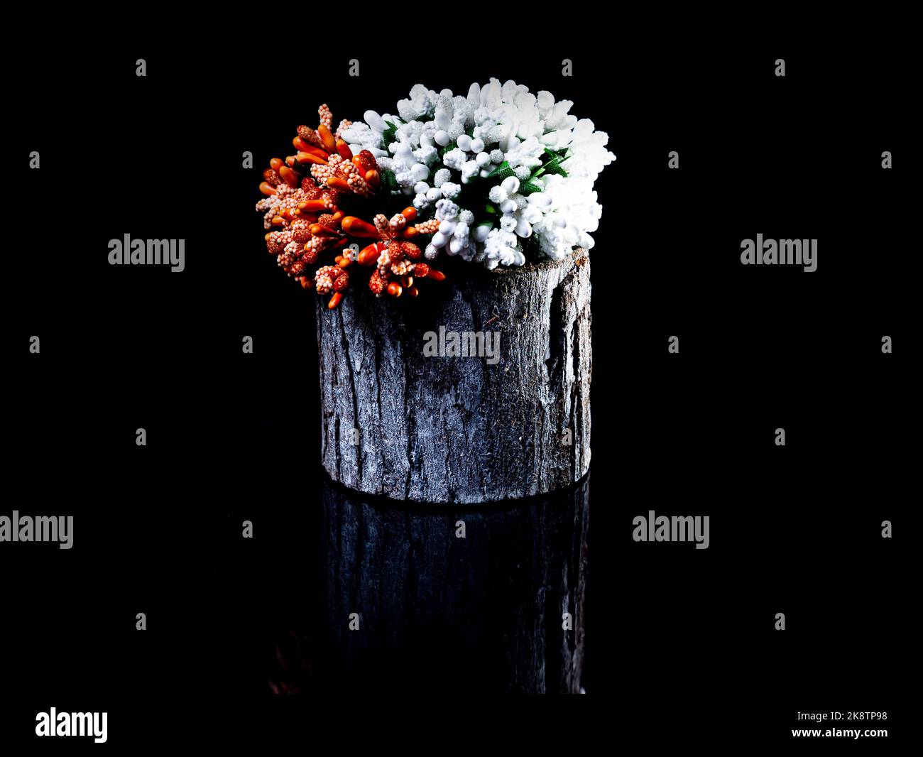 A close up shot of wooden vase with red and white flowers . The ...