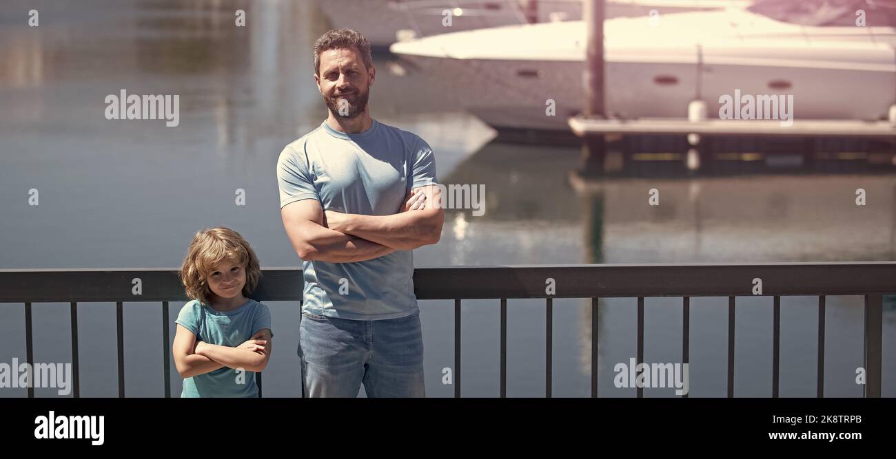 Banner of father man and son child stand on quay railing keeping arms ...