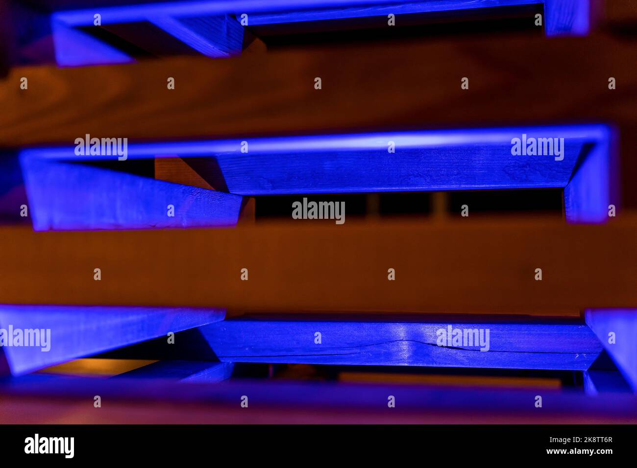 Abstract background of wooden slats illuminated with blue neon light ...