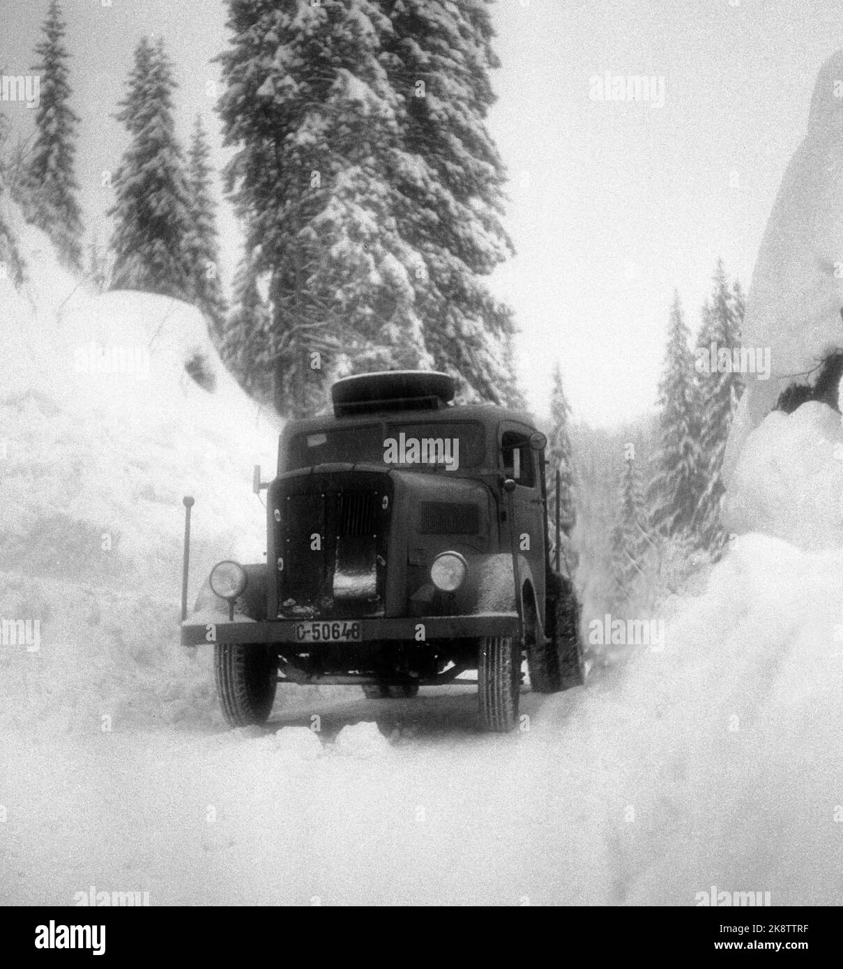 Truck drives in the woods in the winter. 1940s. Running with equipment ...