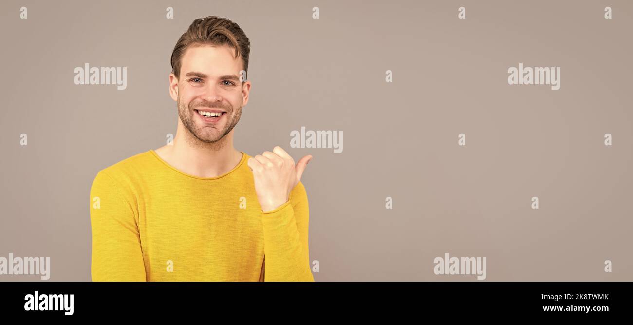 Advertising. Advertising man. Happy guy point finger aside grey ...