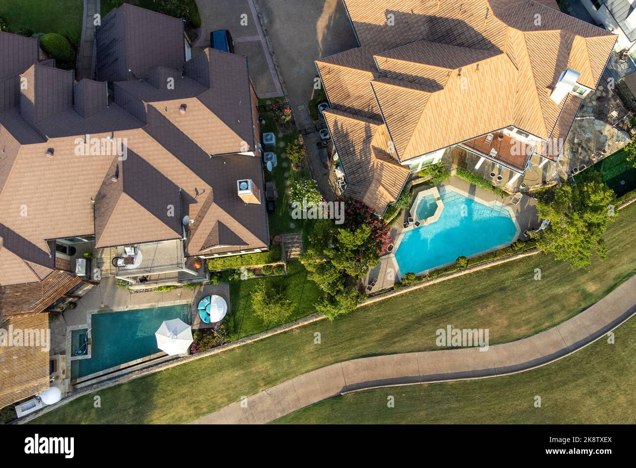 Aerial drone view of luxury mansions with swimming pools surrounded by ...