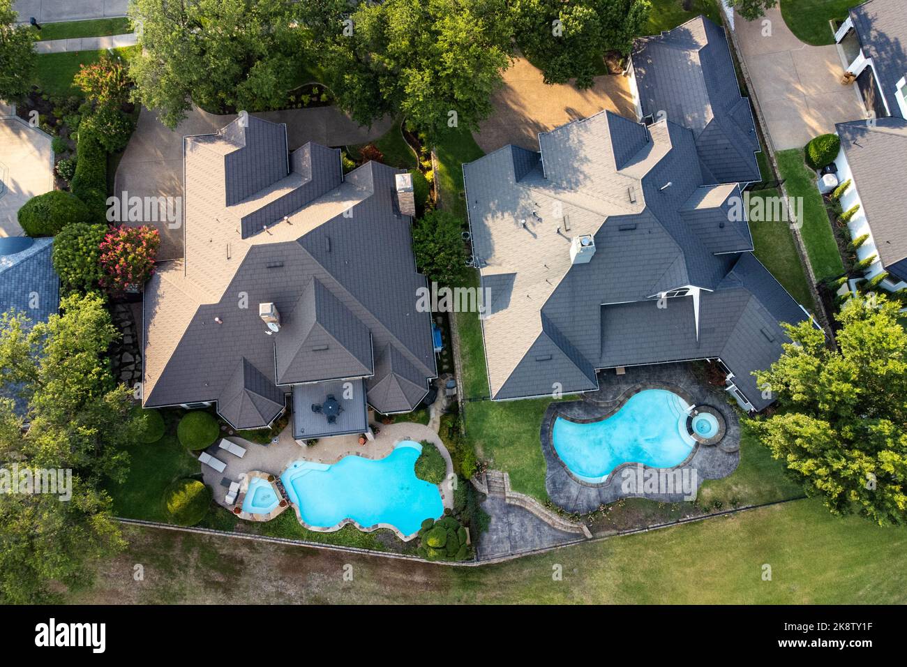 Aerial drone view of luxury mansions with swimming pools surrounded by ...