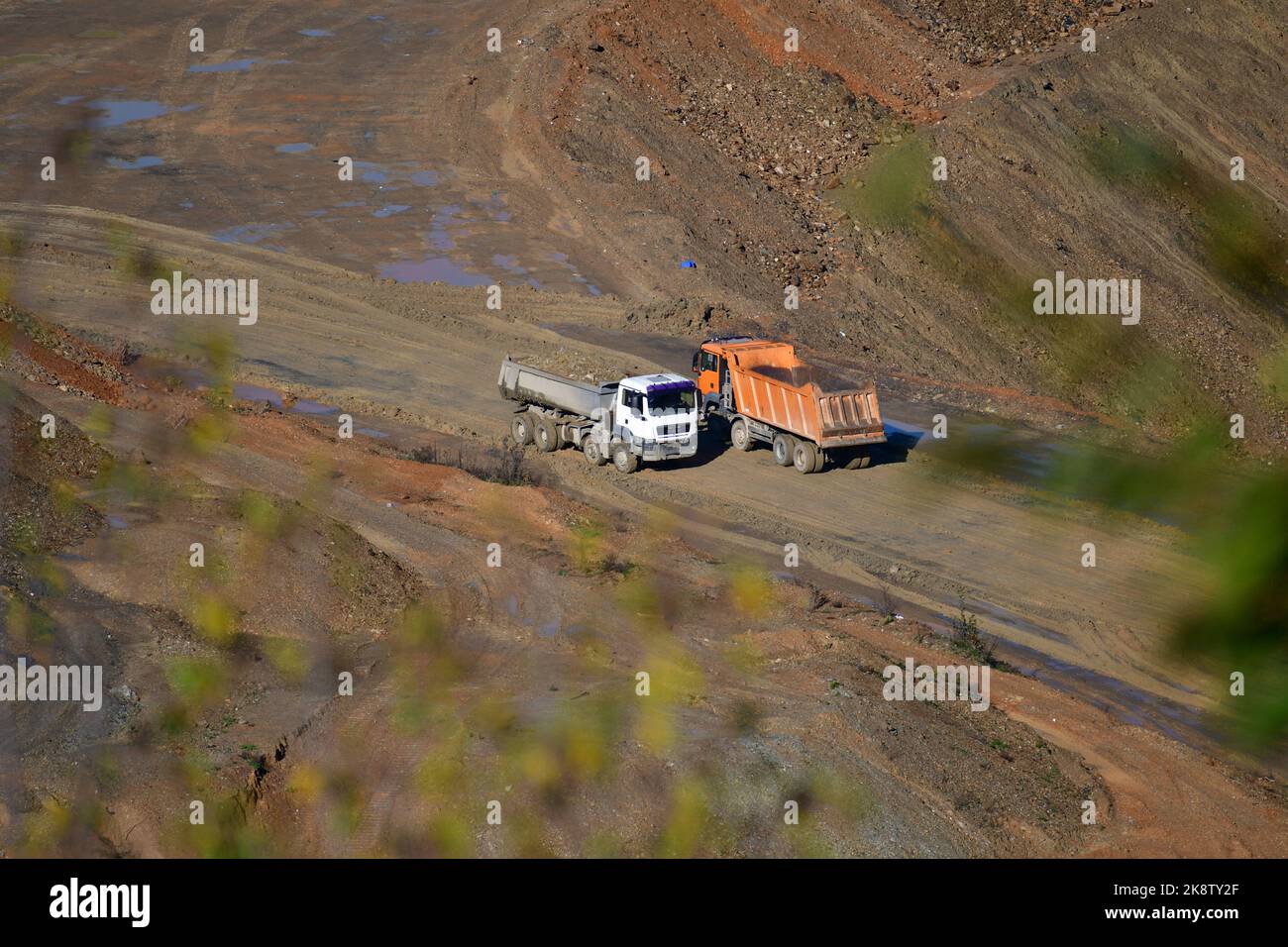 Large trucks transport excavated earth and rocks for highway ...