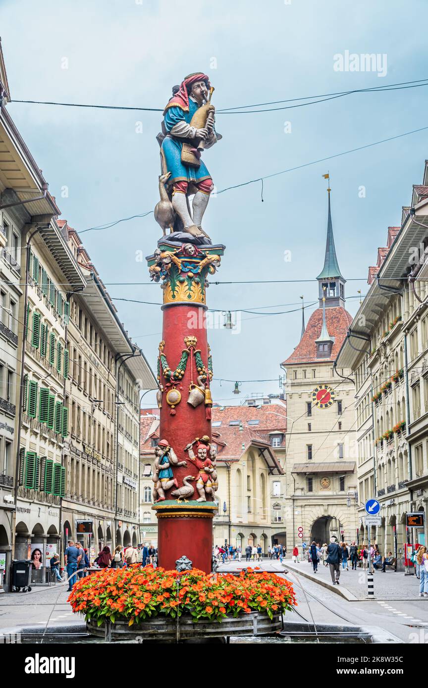 Painted statue at the top of a column of a fountain in the old town of ...