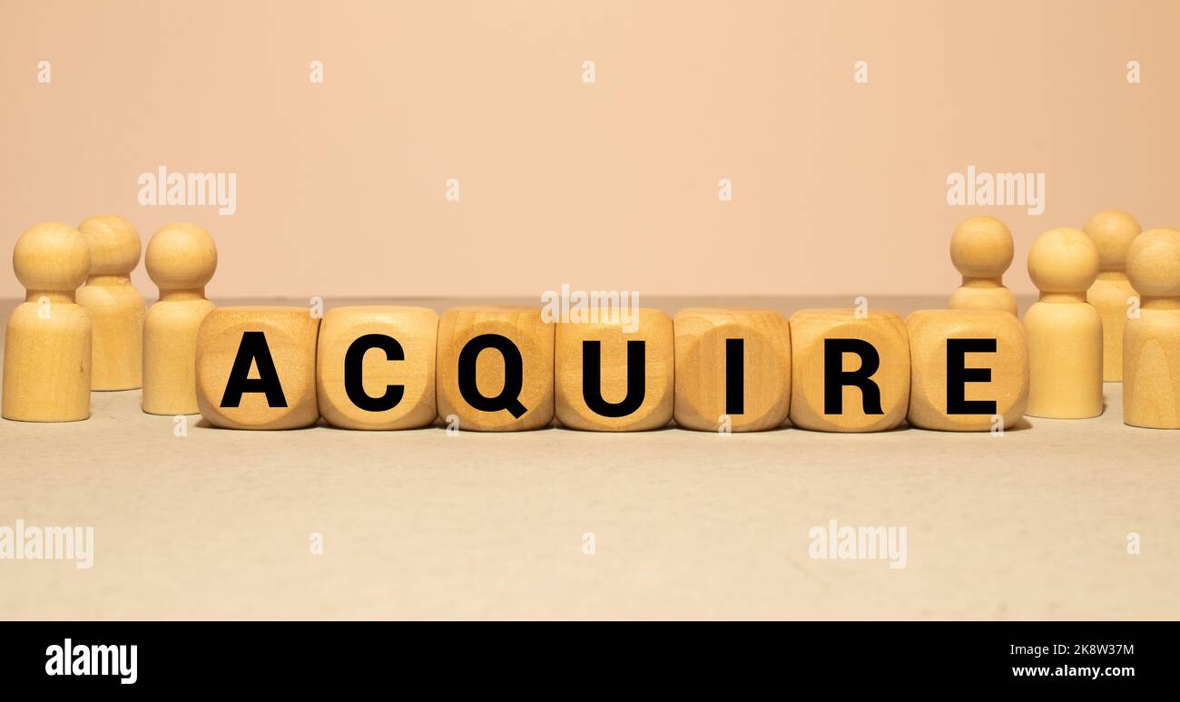 word Acquire on wooden block Stock Photo - Alamy
