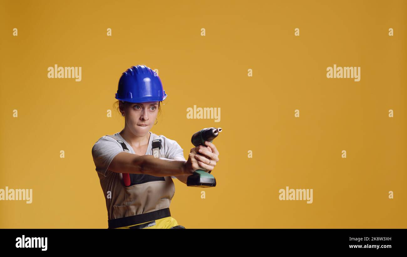 Construction worker having fun with power drill machine, fooling around ...