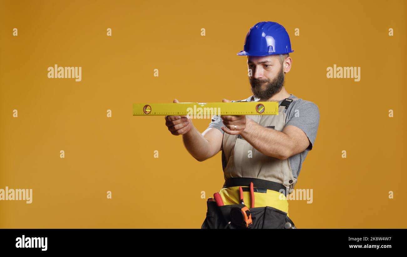 Construction builder working with water level tool to do measurement ...