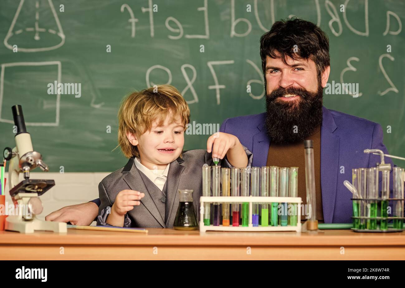 Laboratory test tubes and flasks with colored liquids. father and son ...
