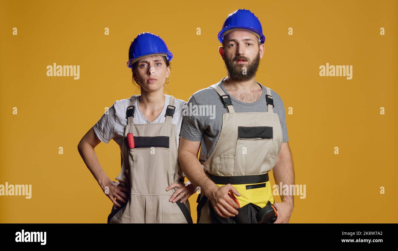 Happy constructors dancing and singing in studio, having overalls and ...