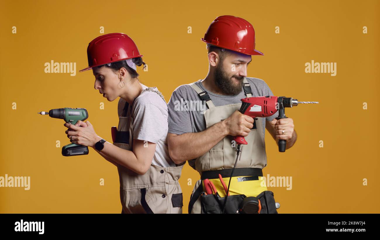 Construction workers using power drill gun to work on industrial ...