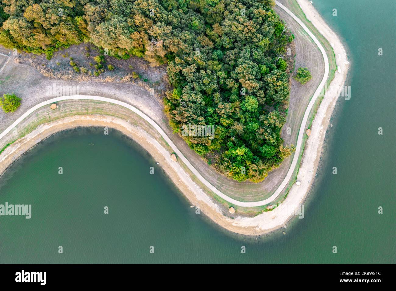 Aerial view of island with green trees and roads surrounded by sea or ...
