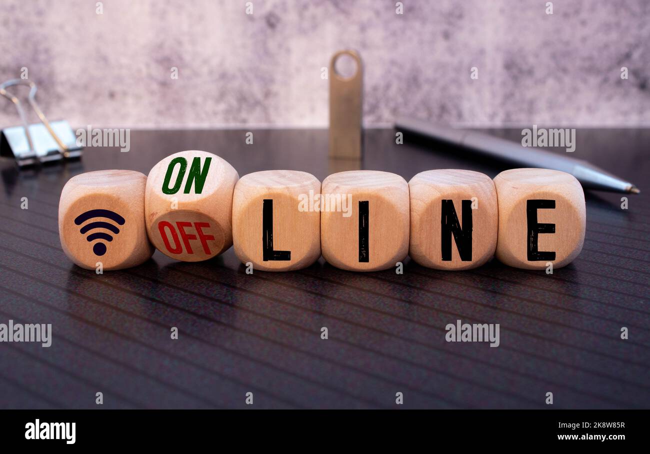 Hand turns a dice and changes the word offline to online or vice versa ...