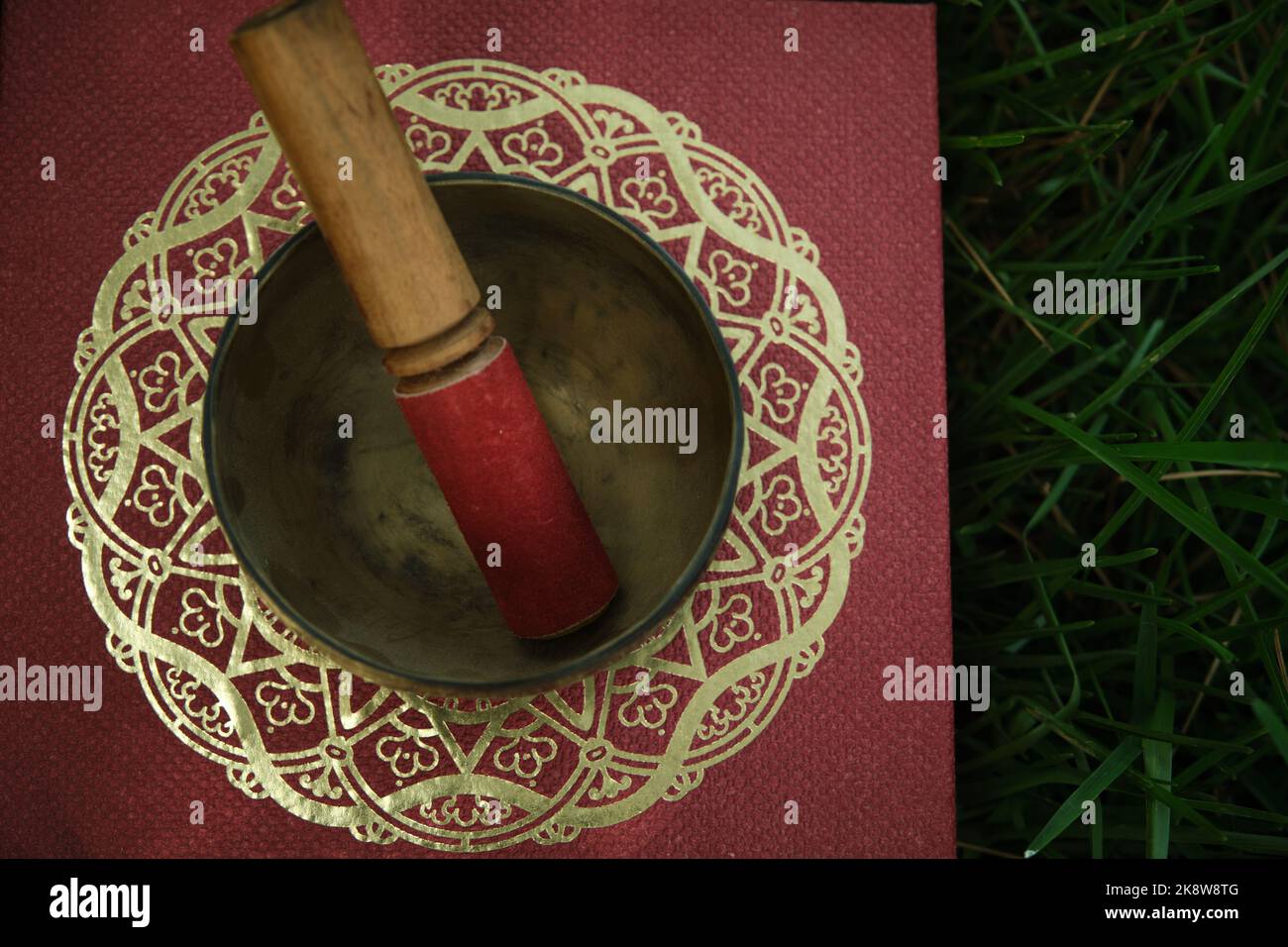 Tibetan bowl with a stick on the grass Stock Photo - Alamy