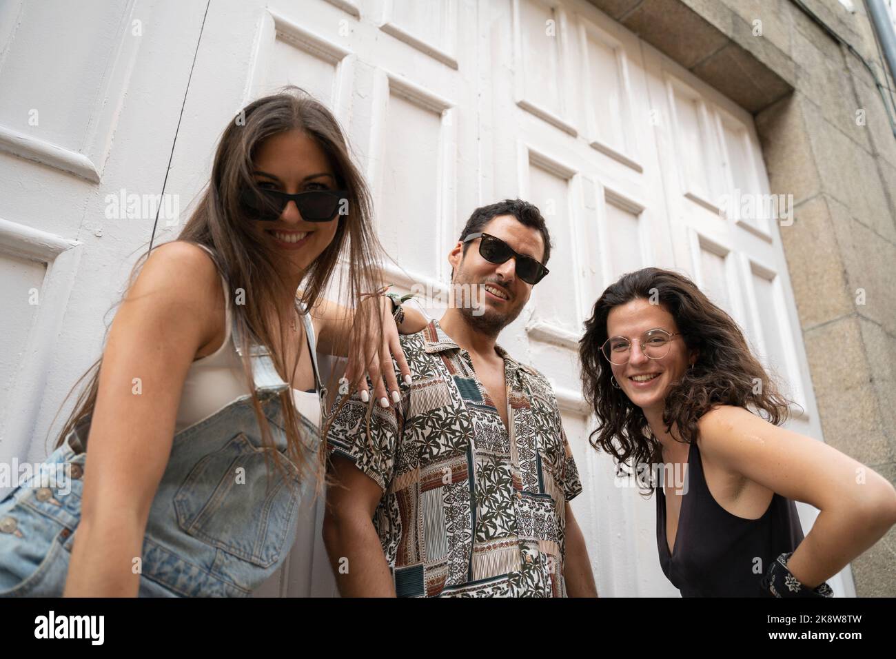 a group of three friends having fun and laughing on a bench in the ...