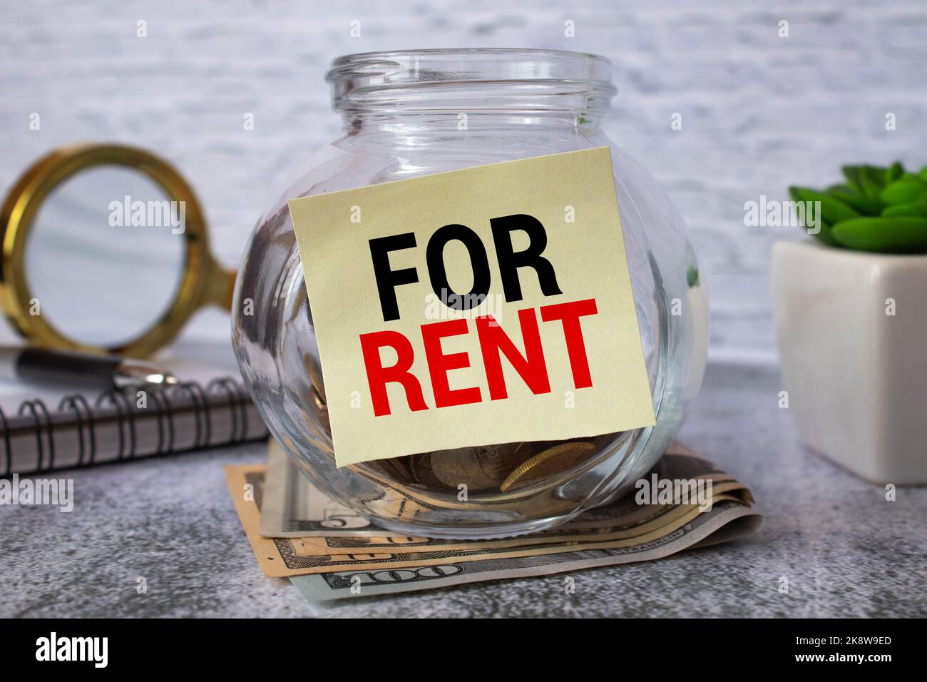 Rent. Glass jar with coins and an inscription rent. Man holds coin in ...