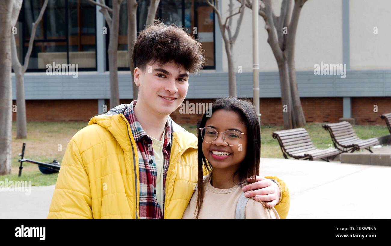 Diverse smiling young teenage couple friends or boyfriends looking at ...