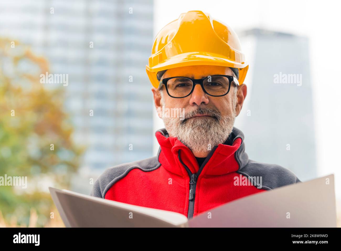 Middle-aged male contractor with beard wearing glasses and hard hat ...